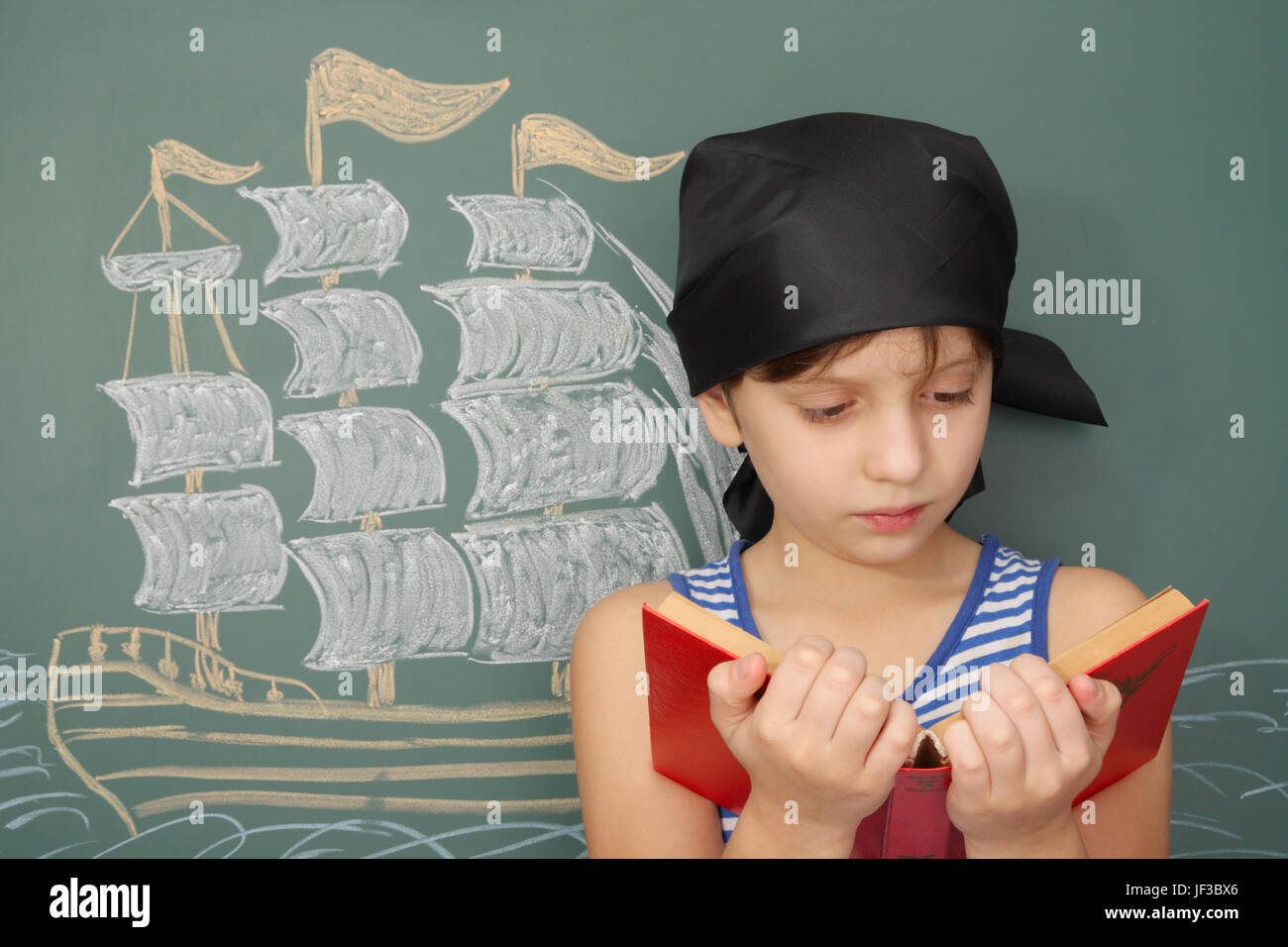 Boy pirate with book and chalk drawing of ship Stock Photo - Alamy