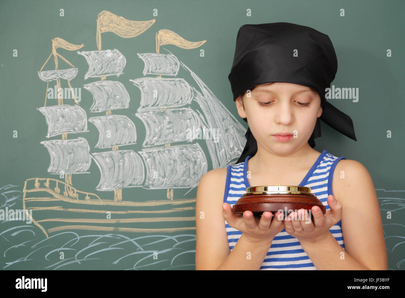 Boy pirate with compass on background of ship Stock Photo - Alamy