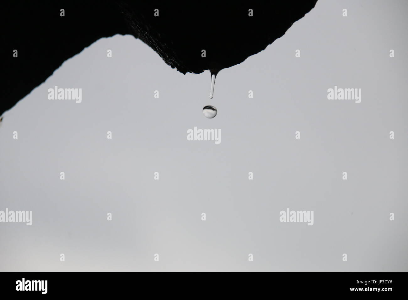 Rain drops falling from old roof Stock Photo - Alamy