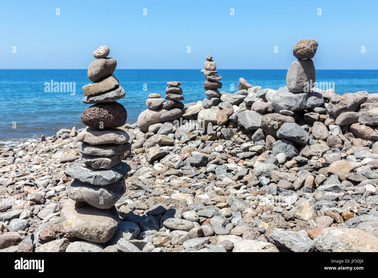 Stacked beach stones at blue sea Stock Photo - Alamy