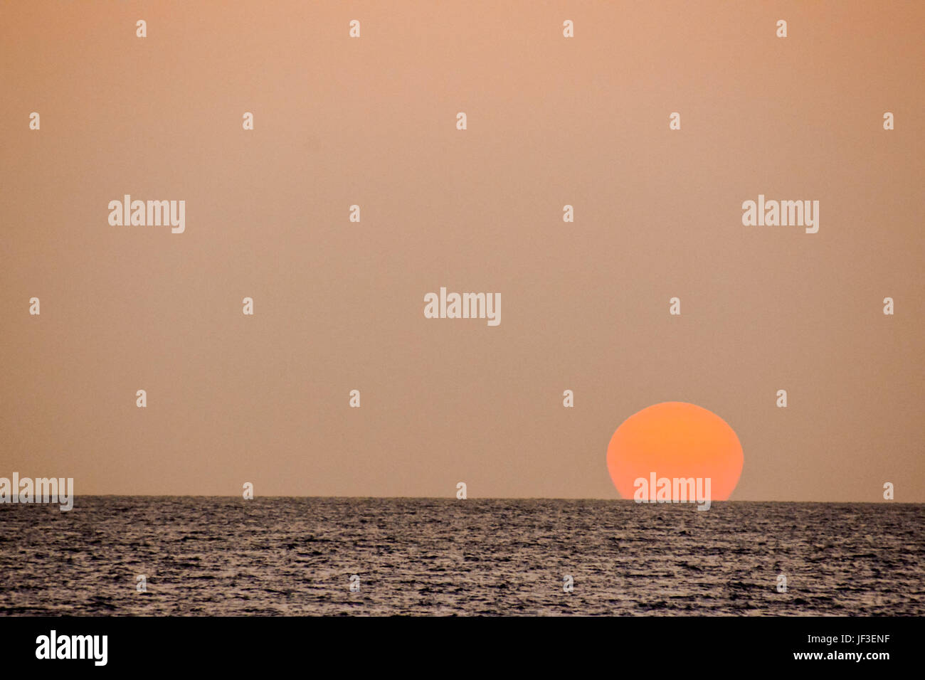 The Sun Setting in the Sea Stock Photo - Alamy