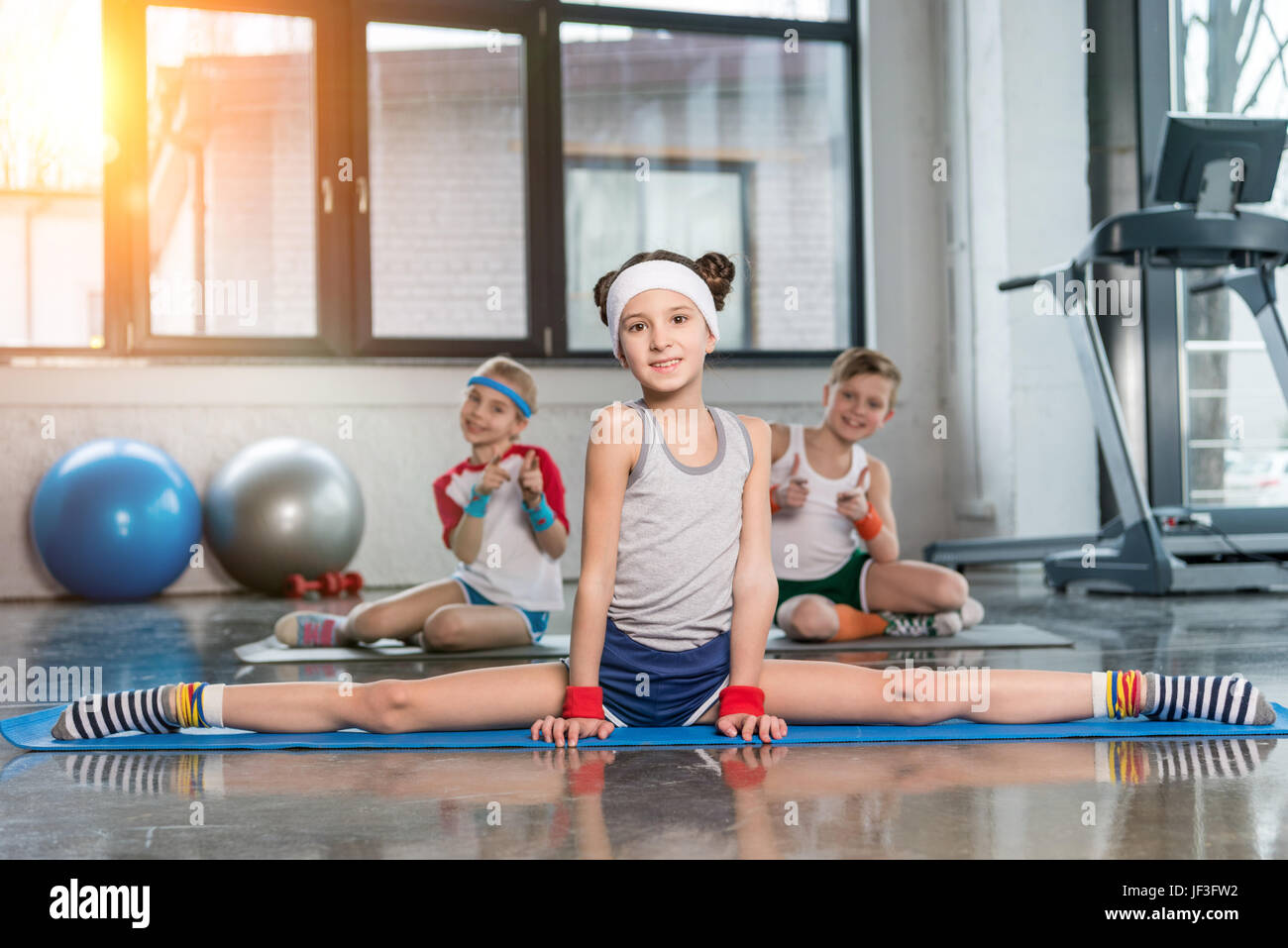 Cute sporty kids exercising in gym and smiling at camera, children ...