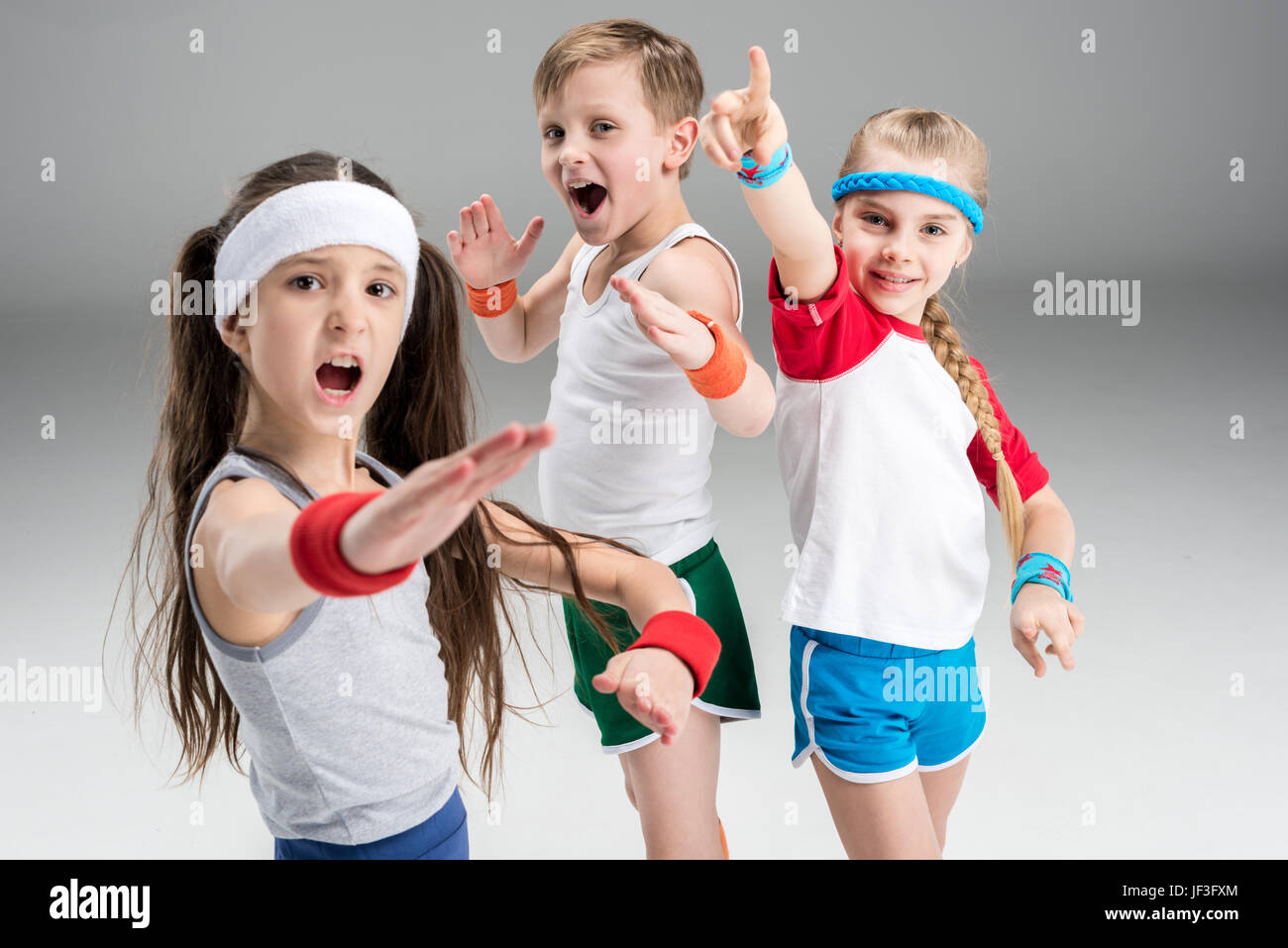 Group of sporty children in sportswear exercising together isolated on ...