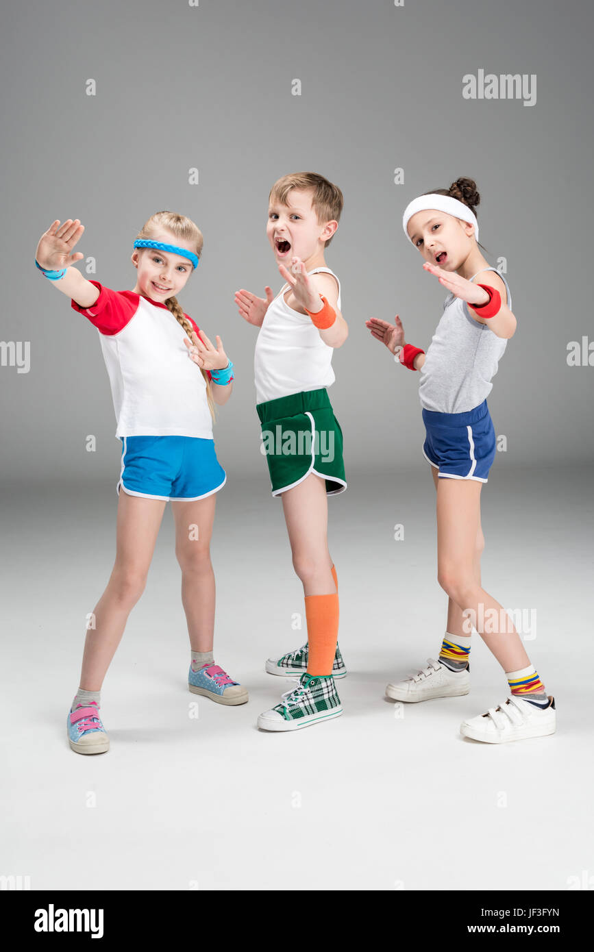 Adorable sporty kids in sportswear standing together and posing ...