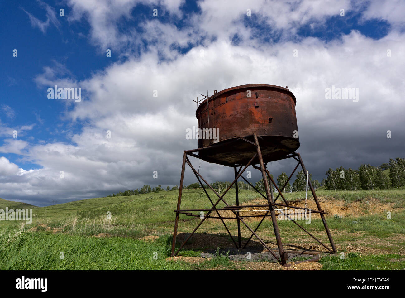 Old rusty water tank on pedestal Stock Photo - Alamy