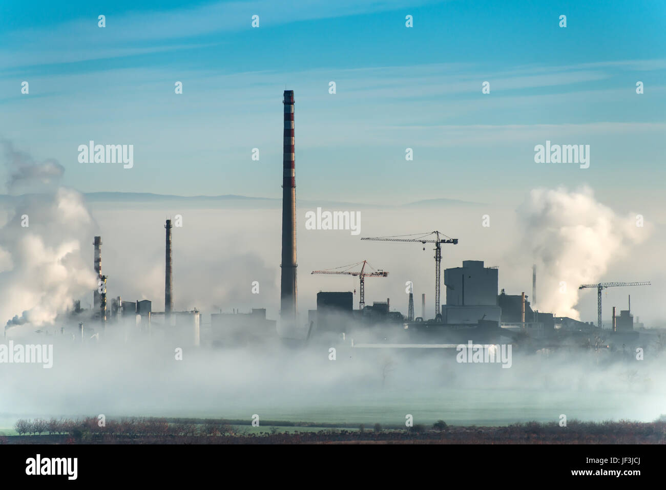 Factory chimneys and clouds of steam Stock Photo - Alamy