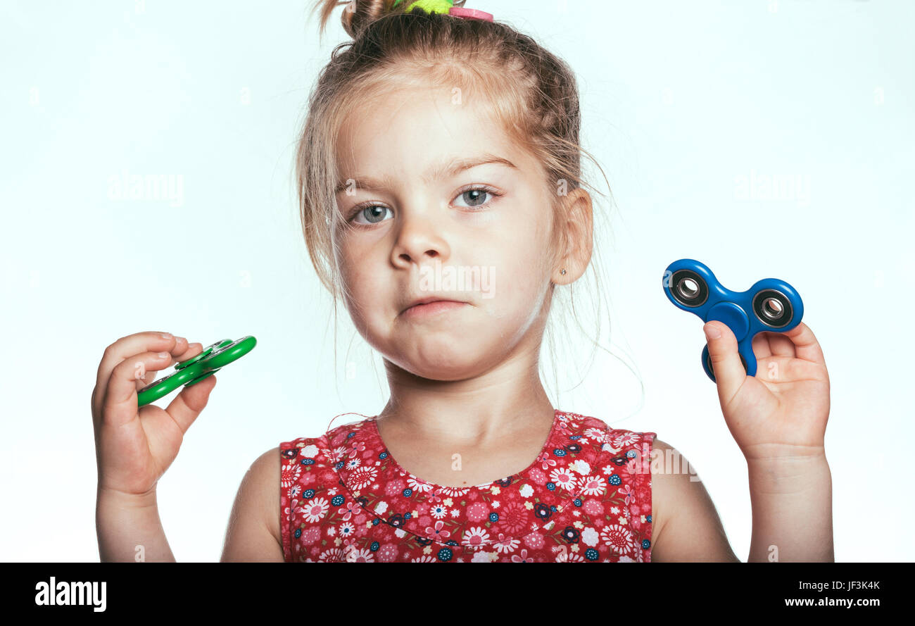 Little girl playing with fidget spinner, on white background. faded ...