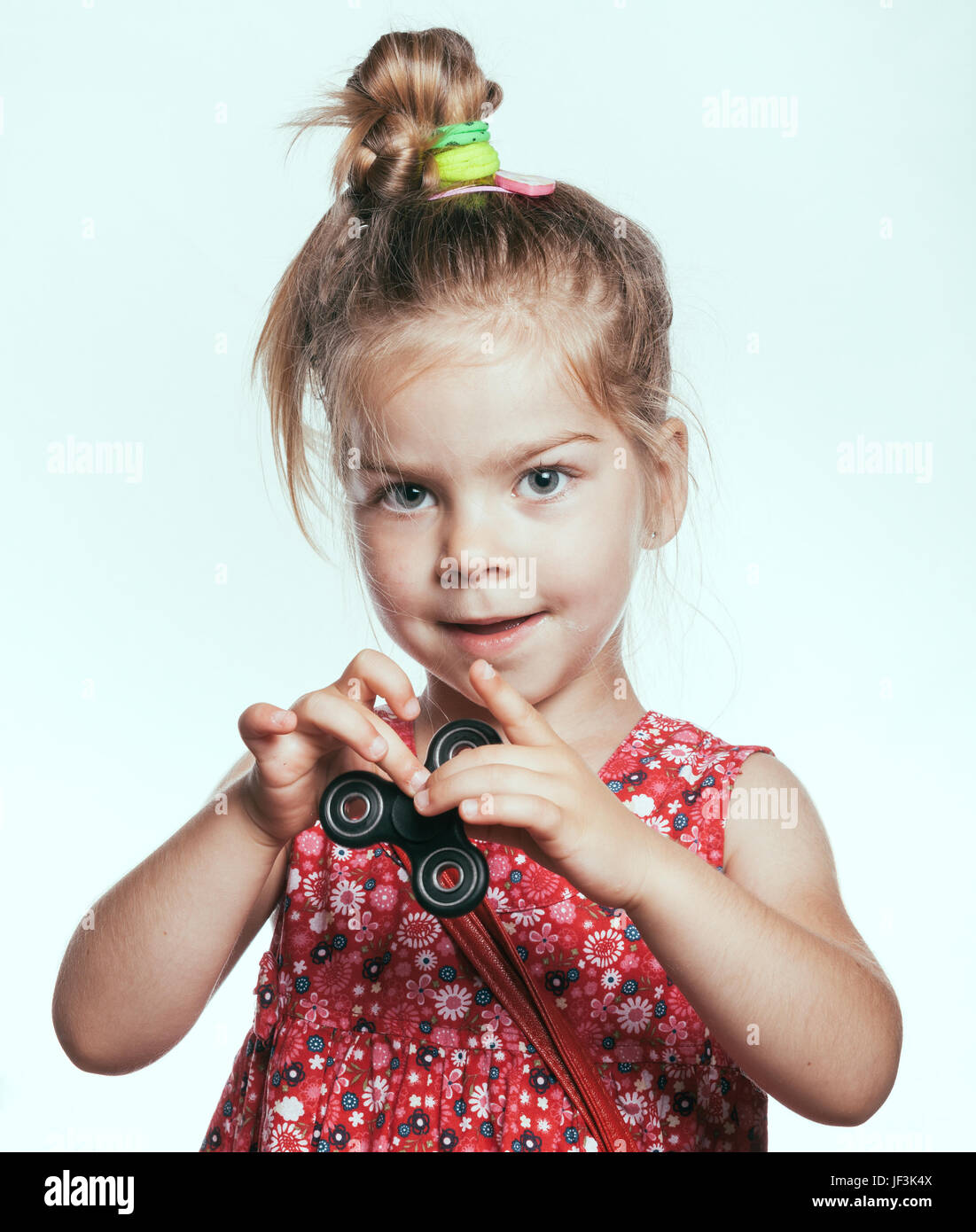 Little girl playing with fidget spinner, on white background. faded ...