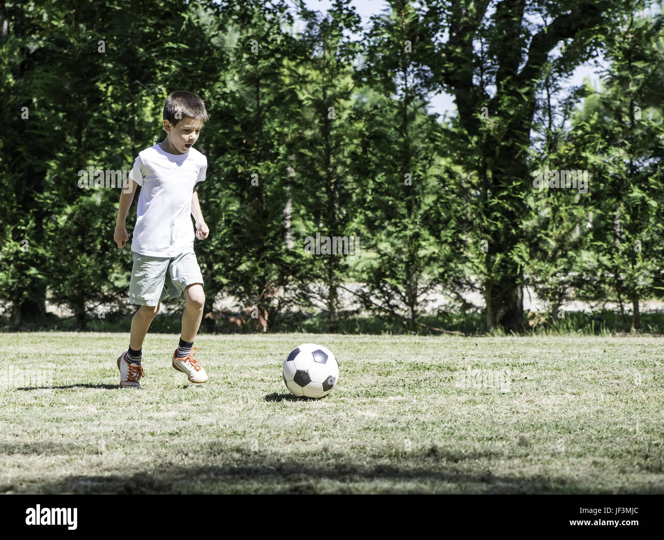 Child playing football in a stadium Stock Photo - Alamy