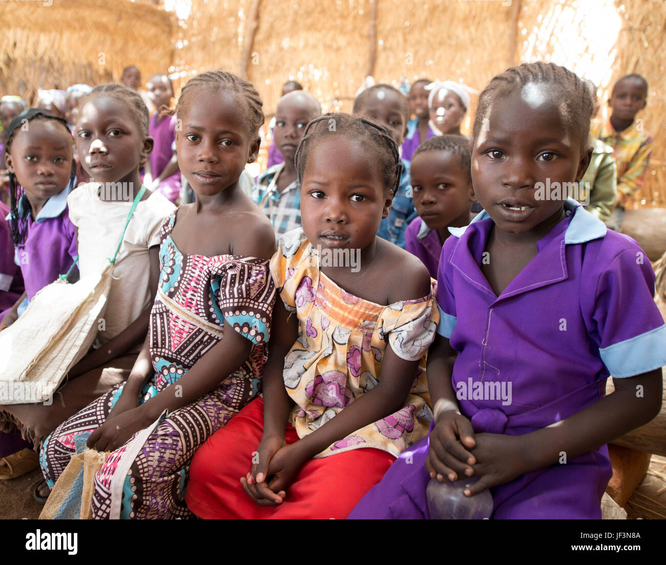 Students sit inside their primary school, a thatched hut with three ...