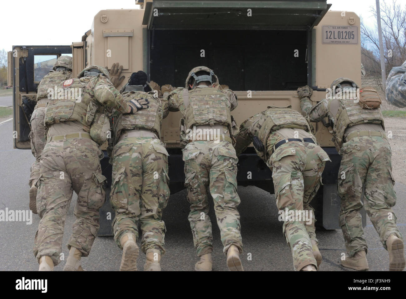 The 91st Security Forces Group Global Strike Challenge team pushes a Humvee at Minot Air Force ...
