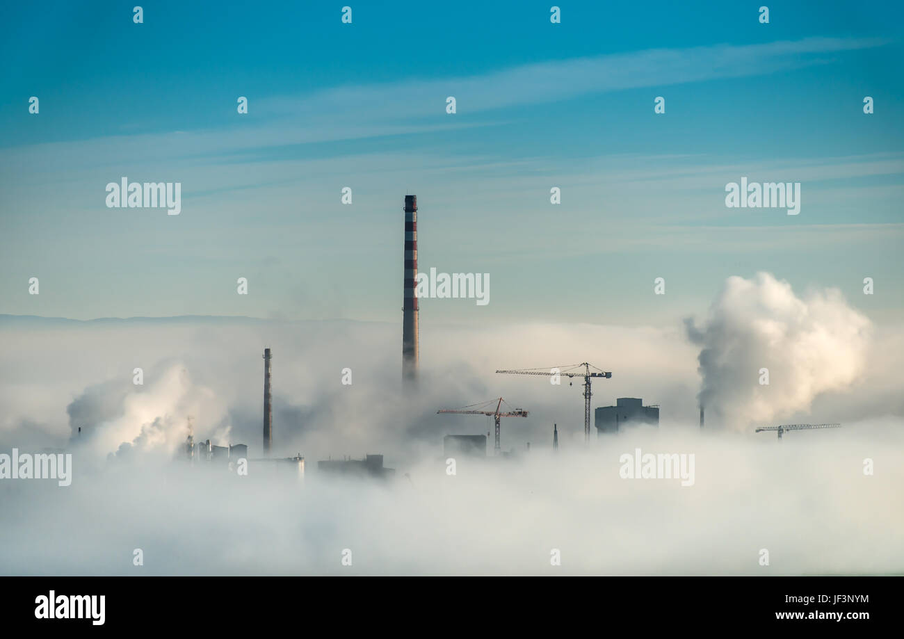 Factory chimneys and clouds of steam Stock Photo - Alamy