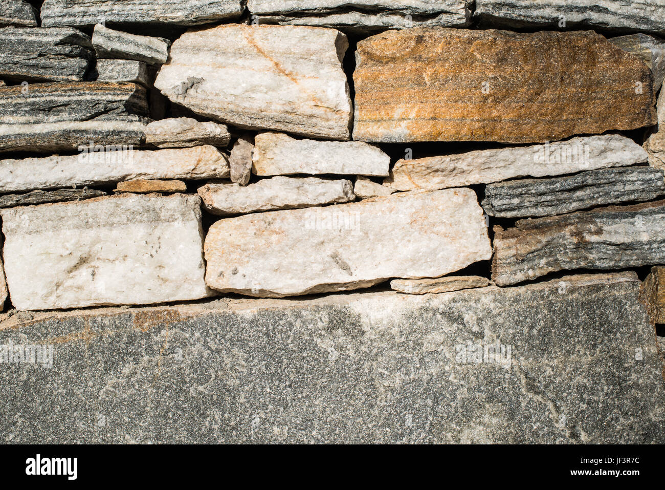 Wall built of stones. Sun light Stock Photo - Alamy