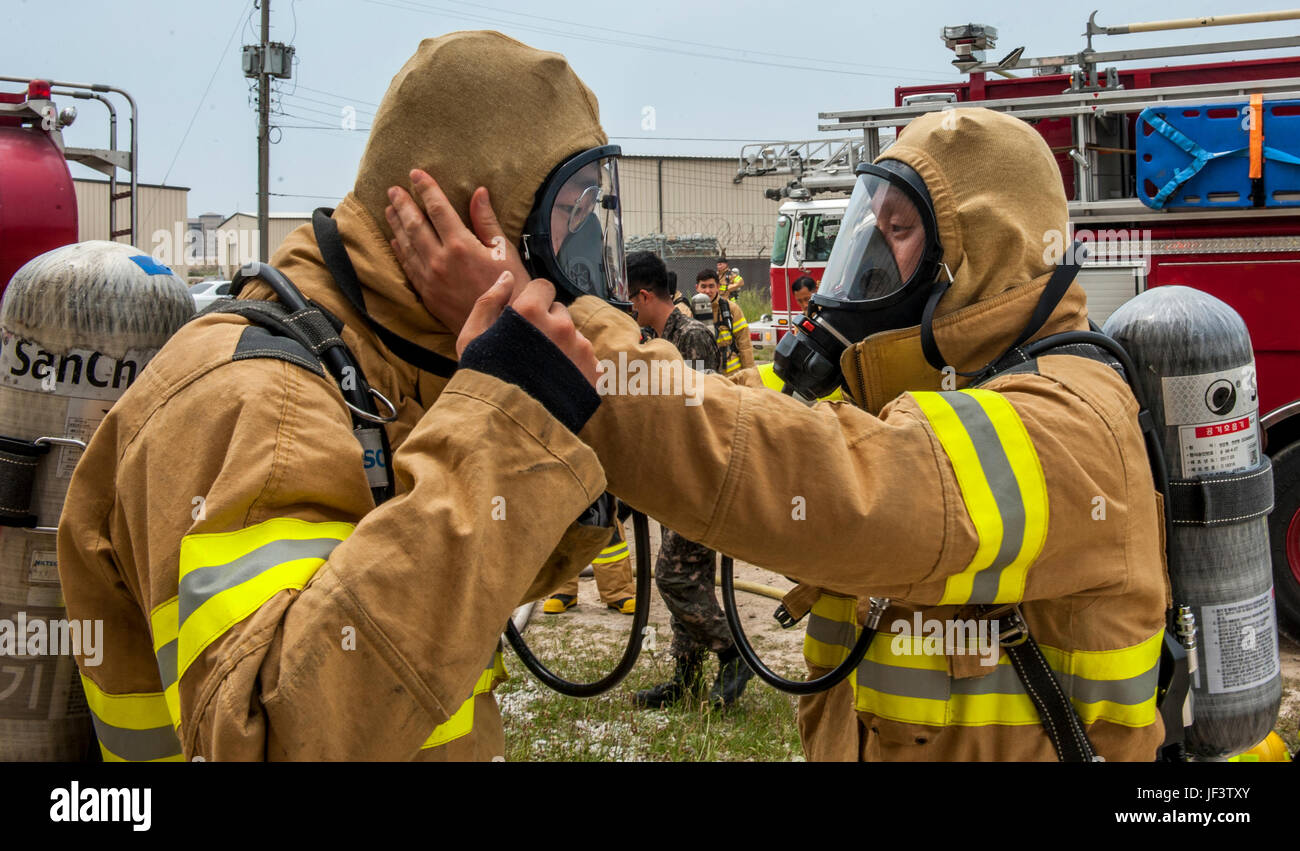 Republic of Korea Air Force firefighters perform buddy checks while ...