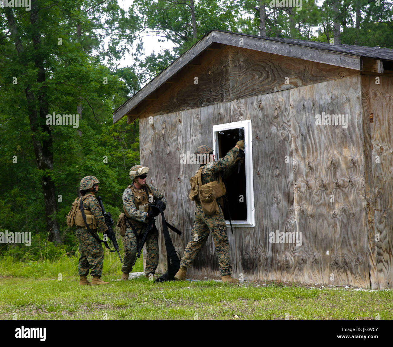 Marines clear debris from a window after using a window charge as a ...