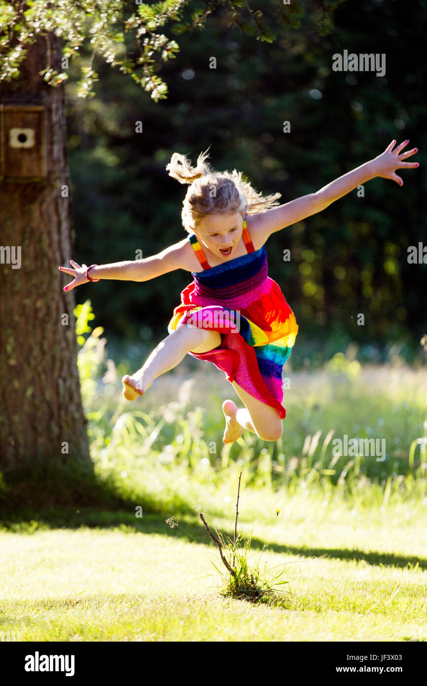 Girl jumping in garden Stock Photo - Alamy