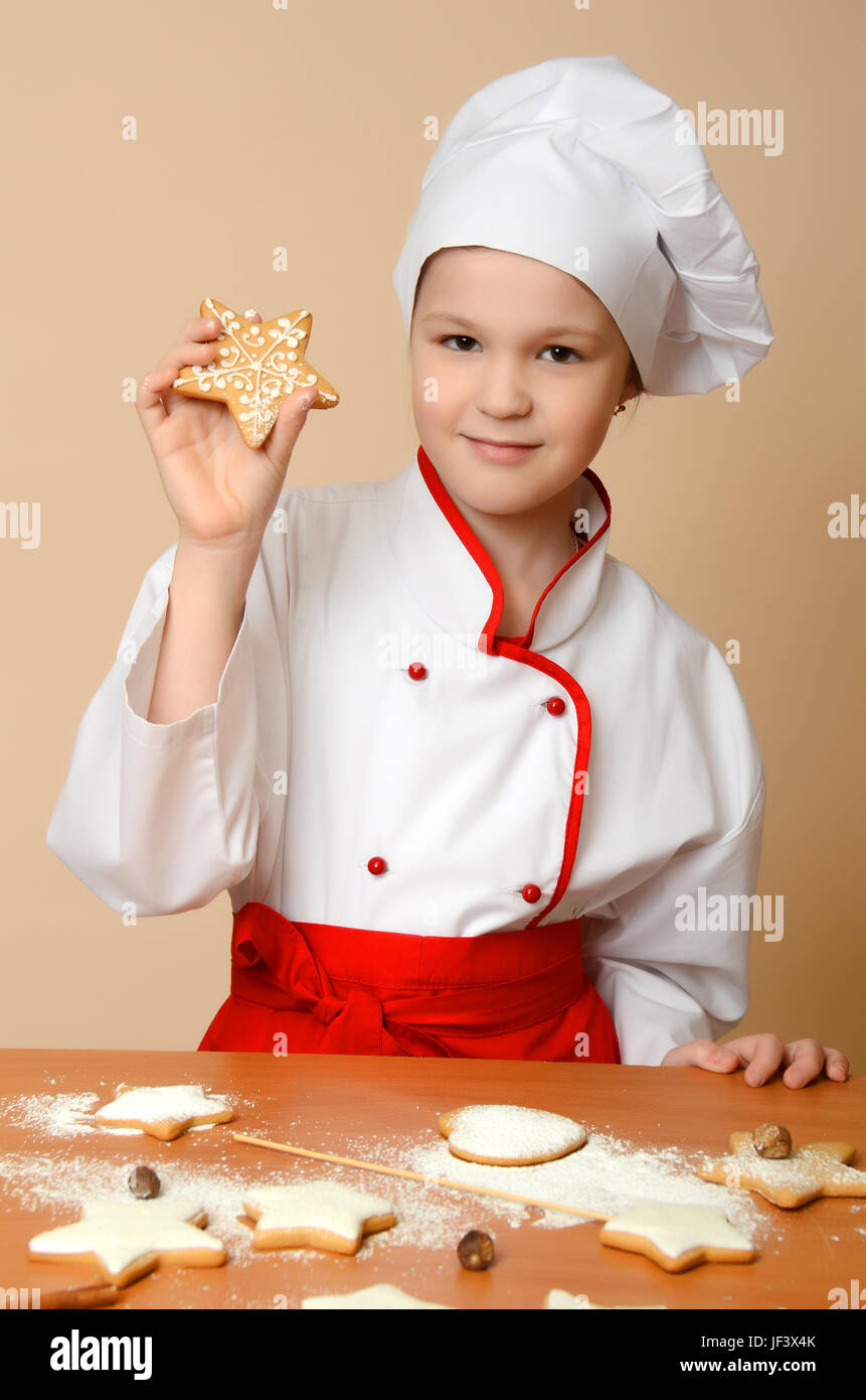 Little cook girl tasting cookies Stock Photo - Alamy