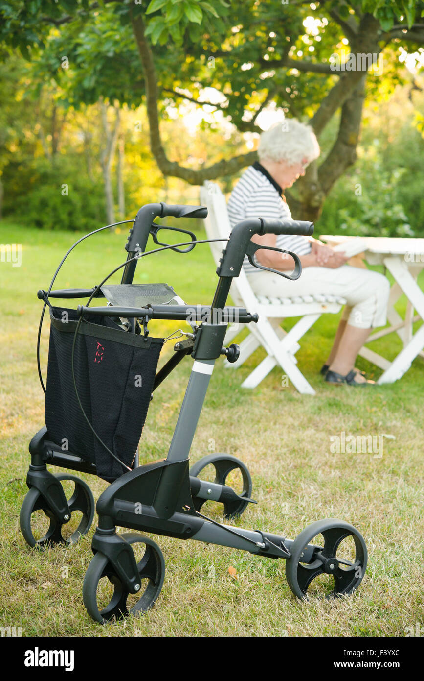 Walking frame, woman in garden on background Stock Photo - Alamy