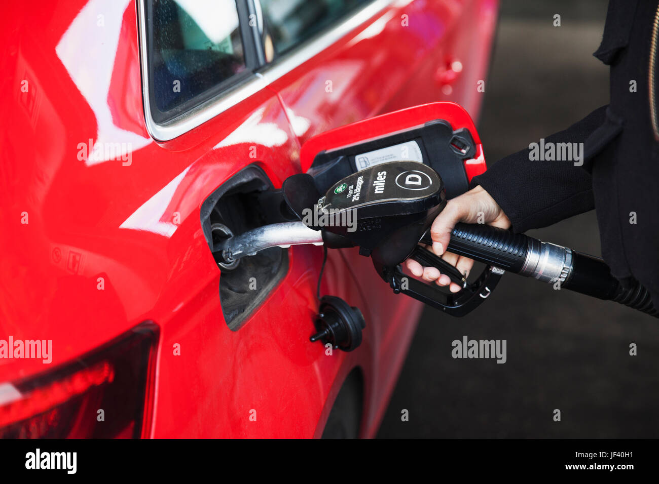 Woman pumping gas Stock Photo - Alamy