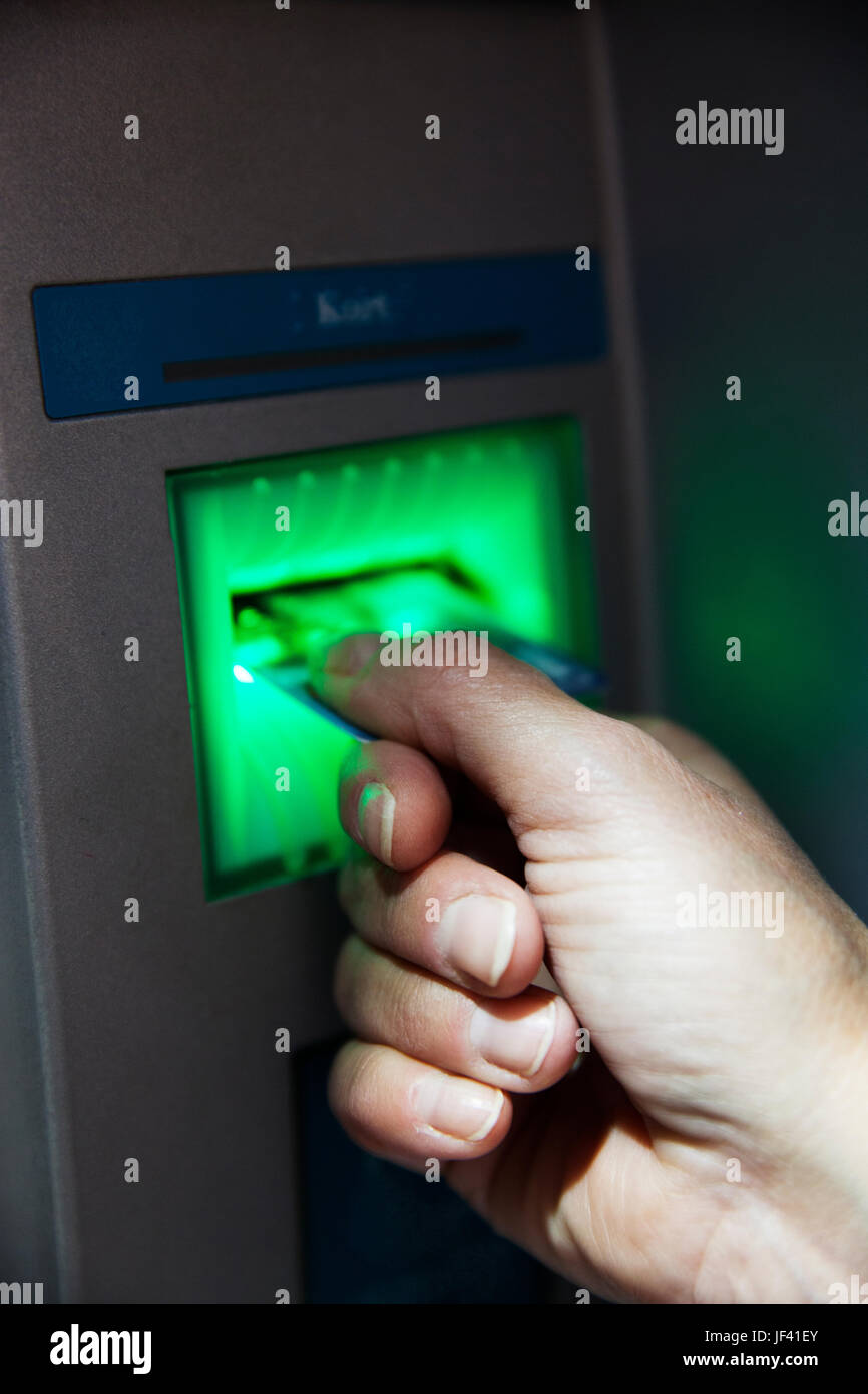 Hand putting bank card into cash machine Stock Photo - Alamy