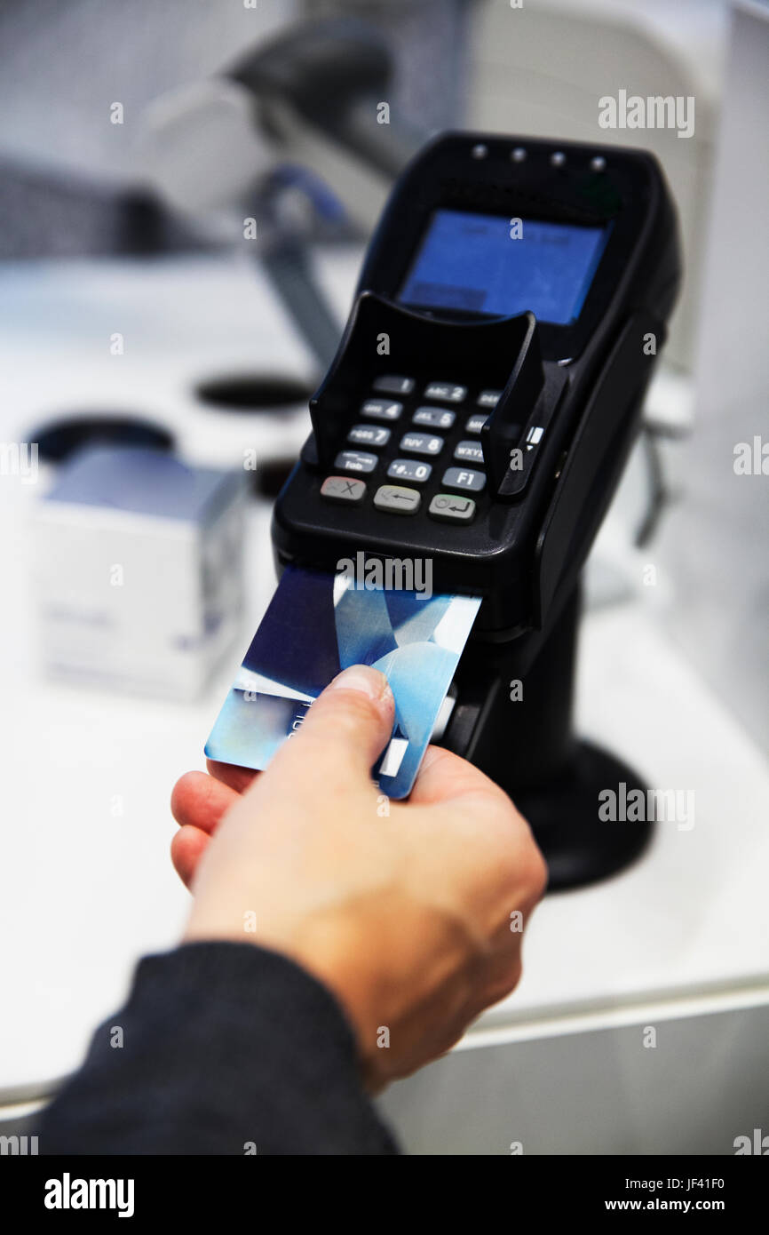 Hand putting bank card into card reader Stock Photo - Alamy