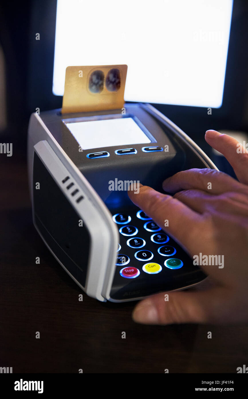 Hand putting bank card into card reader Stock Photo - Alamy