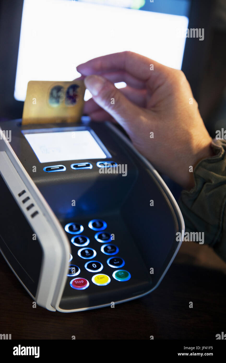 Hand putting bank card into card reader Stock Photo - Alamy