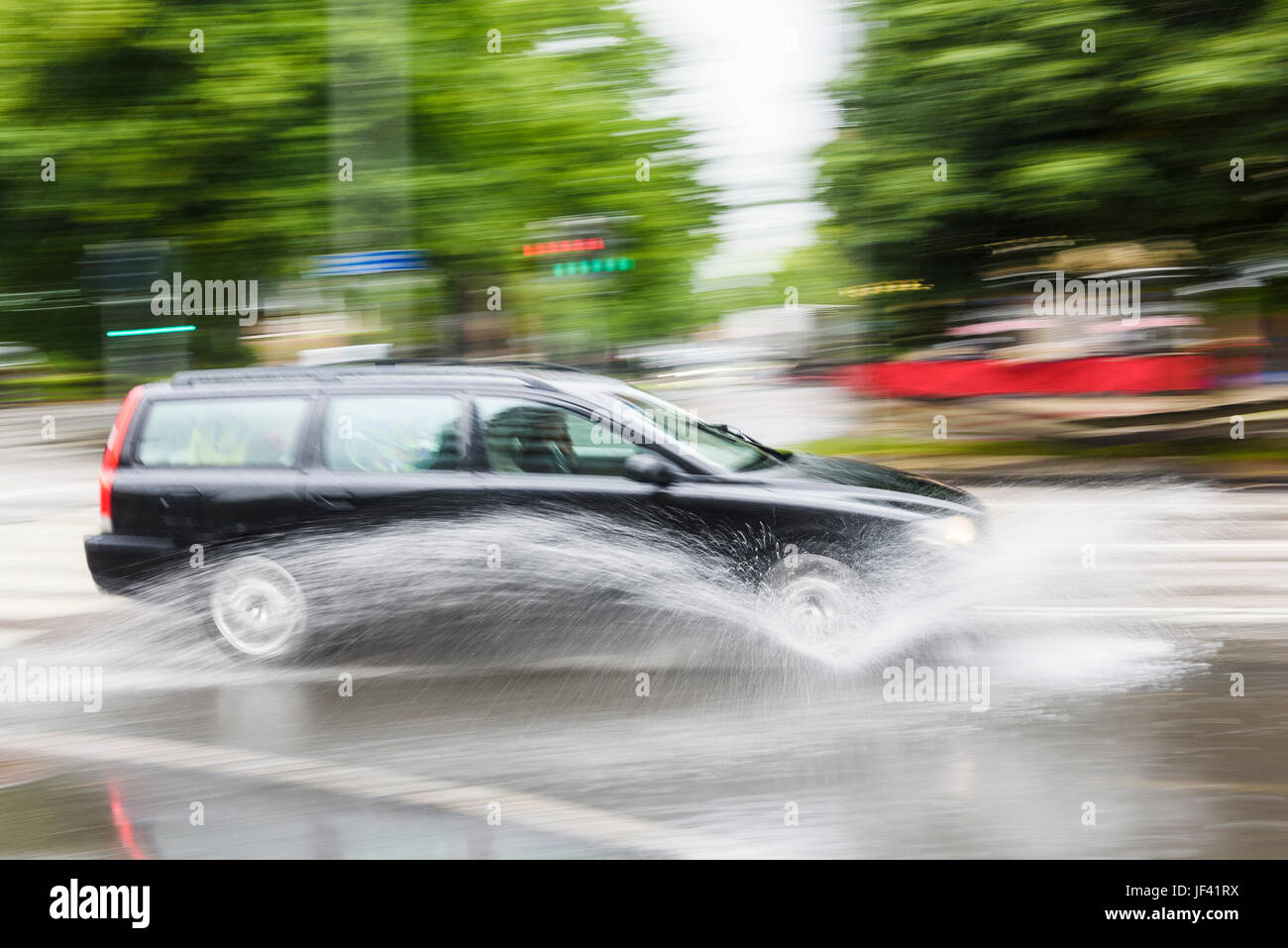 Car splashing water on road Stock Photo - Alamy