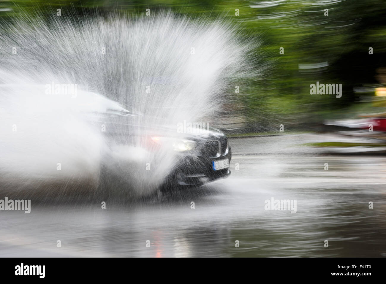 Car splashing water on road Stock Photo - Alamy