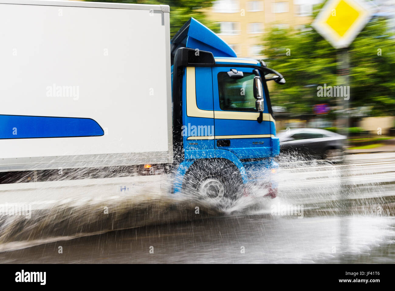 Lorry splashing water on road Stock Photo - Alamy