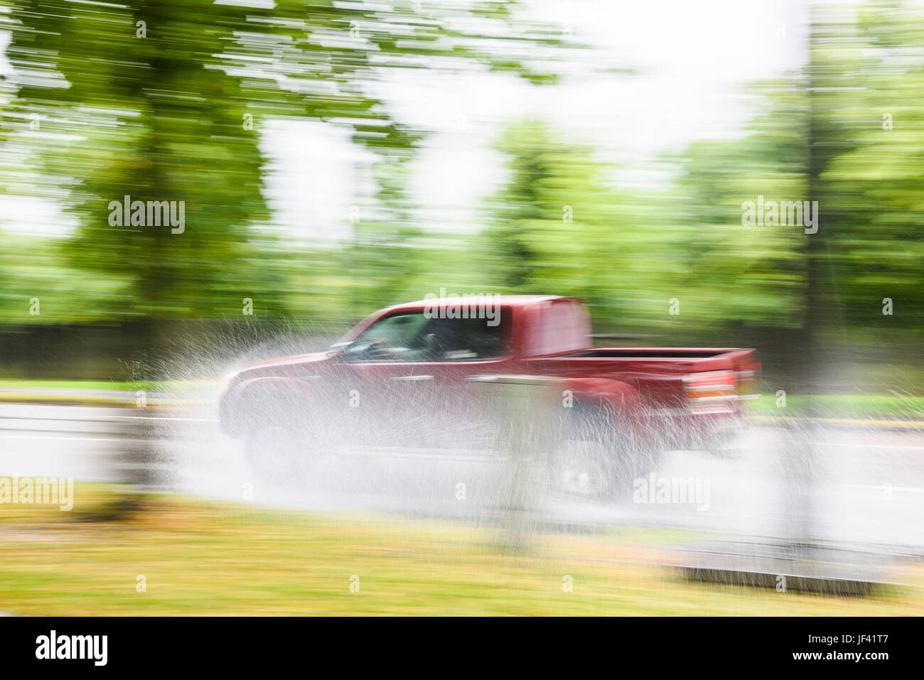 Car splashing water on road Stock Photo - Alamy