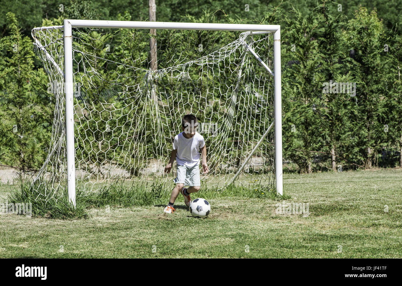 Child playing football in a stadium Stock Photo - Alamy