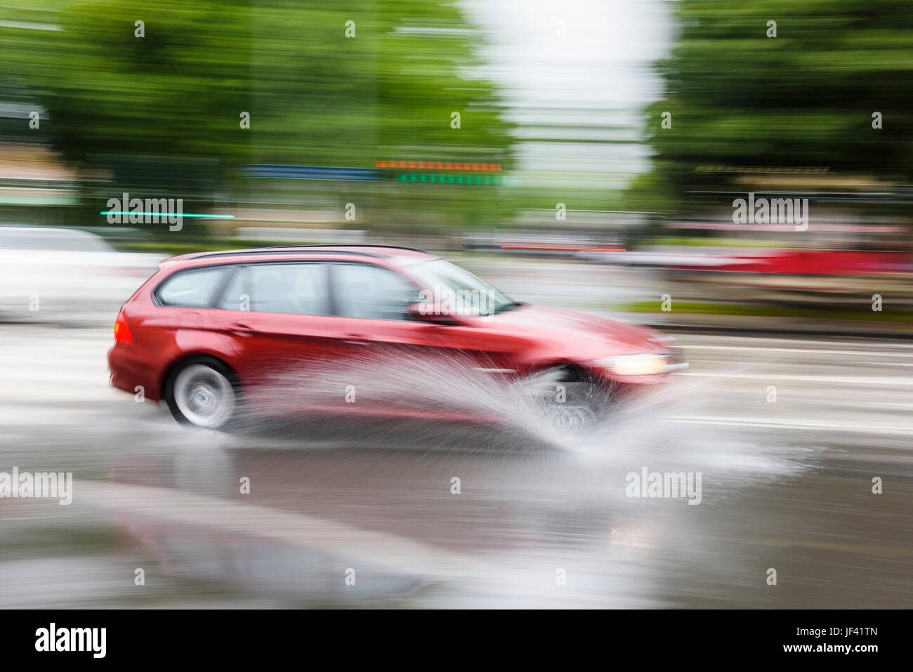 Car splashing water on road Stock Photo - Alamy