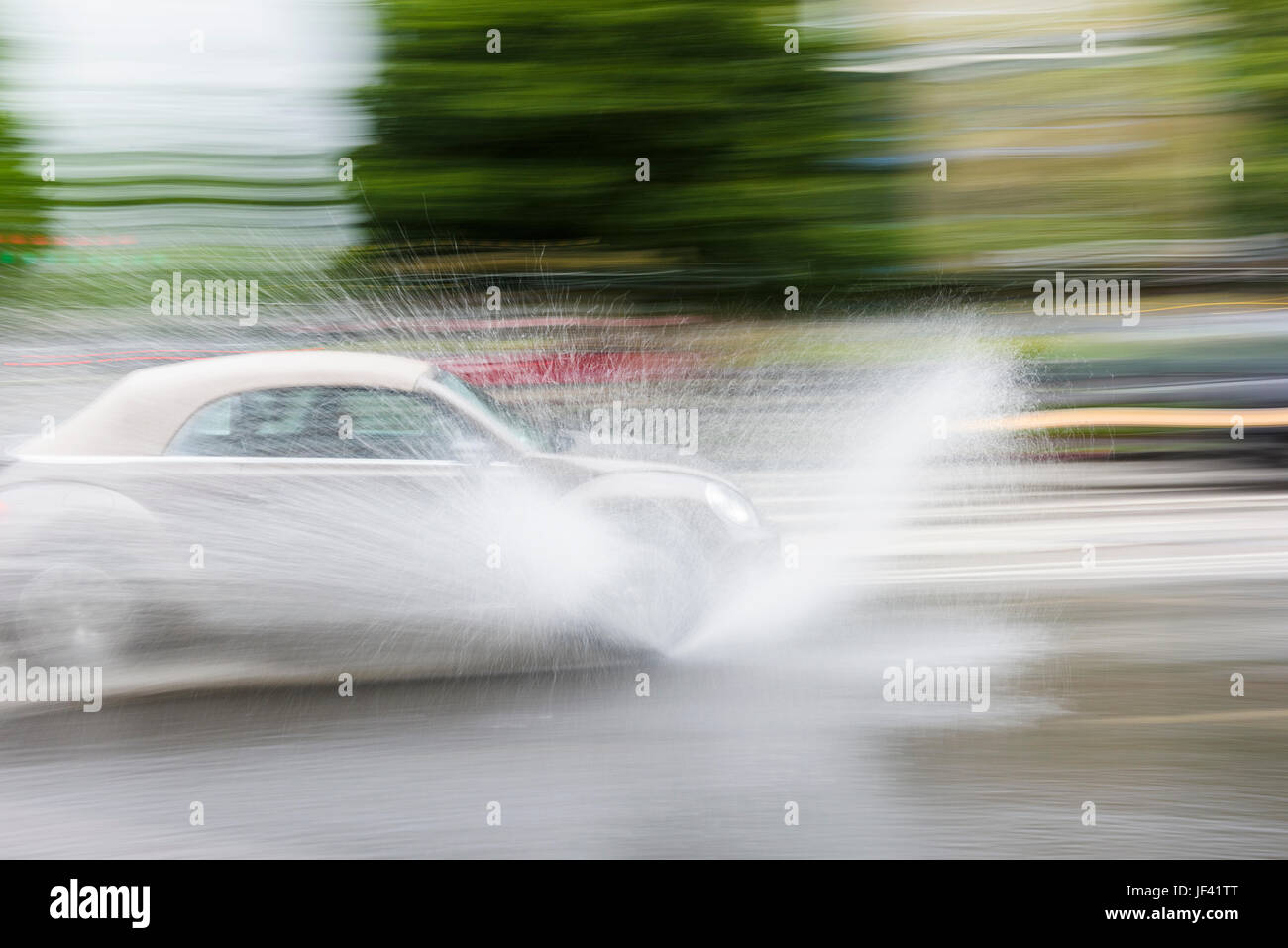 Car splashing water on road Stock Photo - Alamy