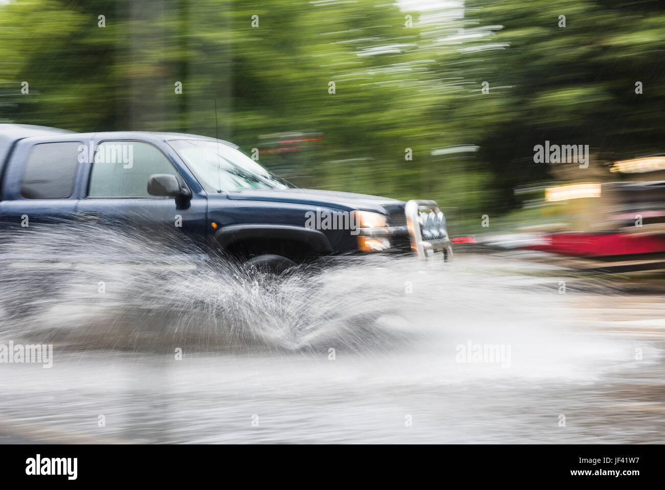 Car splashing water on road Stock Photo - Alamy