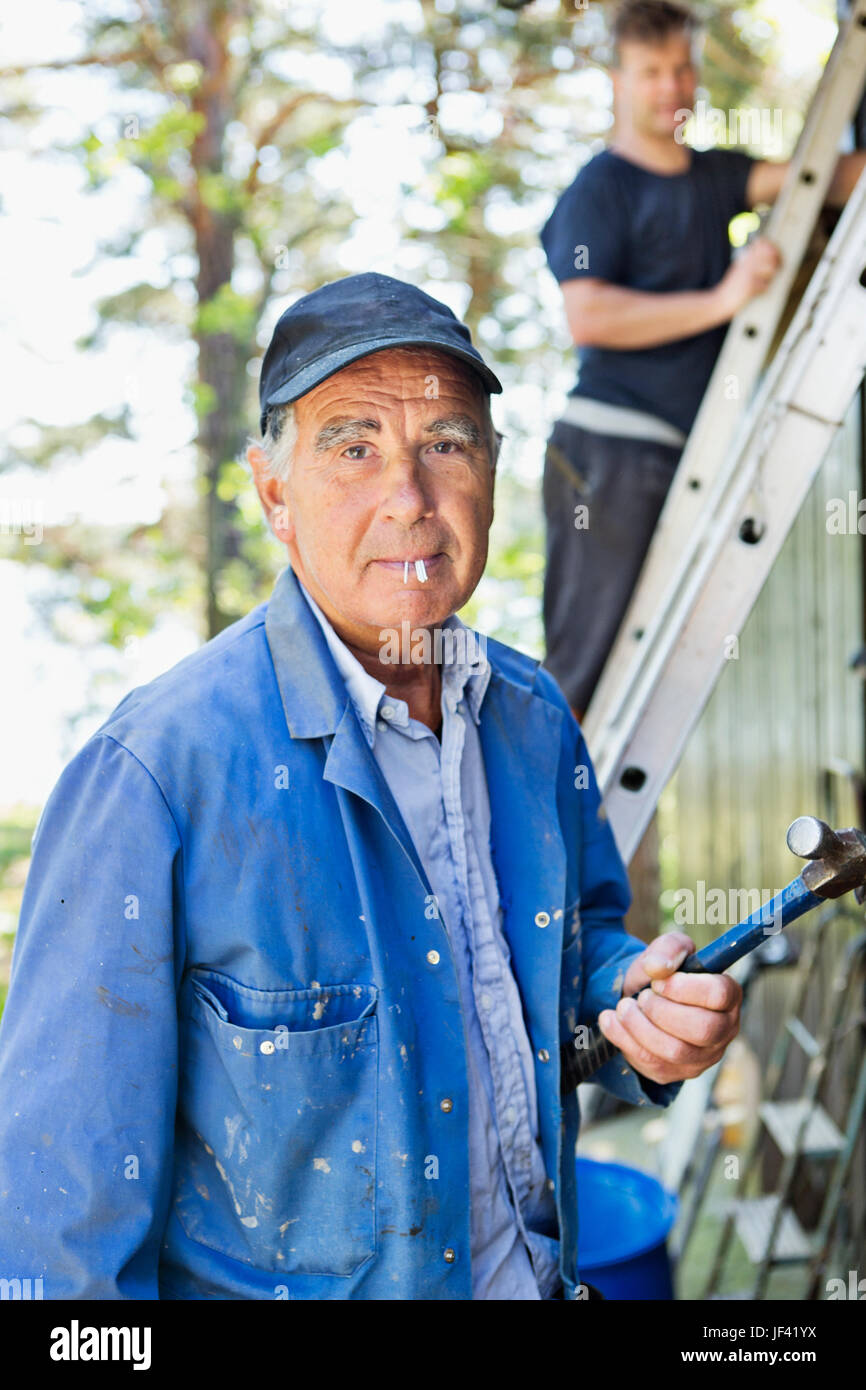 Portrait of senior man with hammer Stock Photo - Alamy