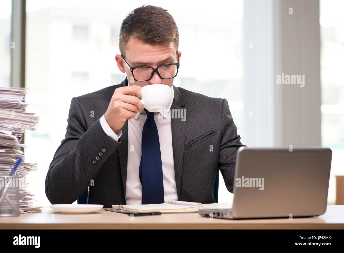 Young businessman drinking tea in the office Stock Photo - Alamy
