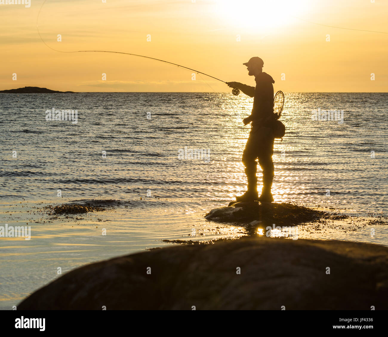 Silhouette of man fishing Stock Photo - Alamy