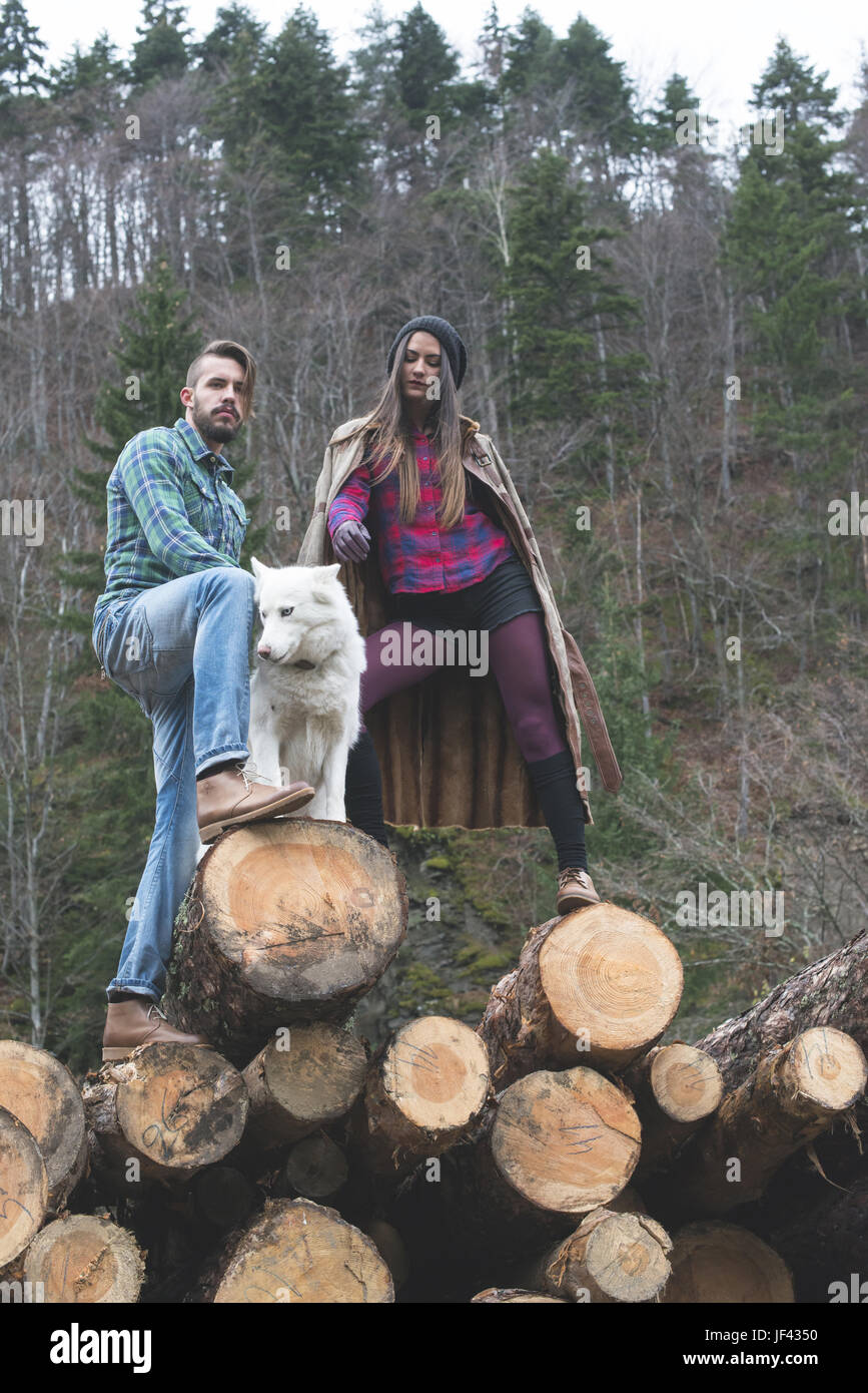 Young woman and men on wood logs Stock Photo - Alamy