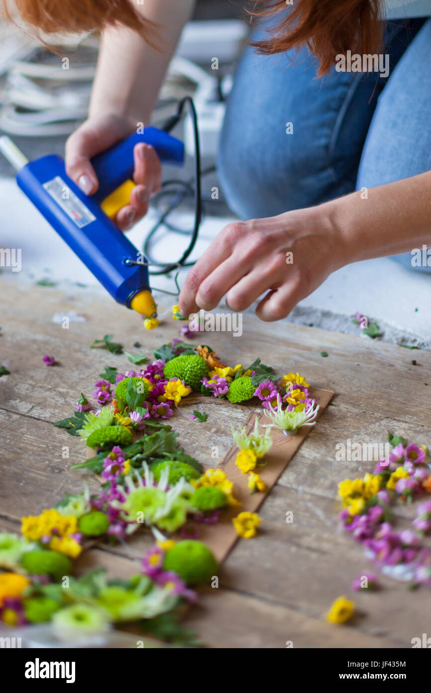 Florist making flower decoration with letters and glue. Indoors natural ...