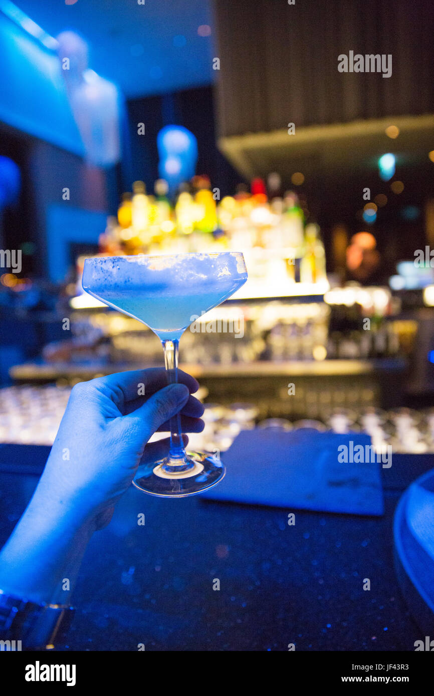 Hand holding cocktail at nightclub Stock Photo - Alamy