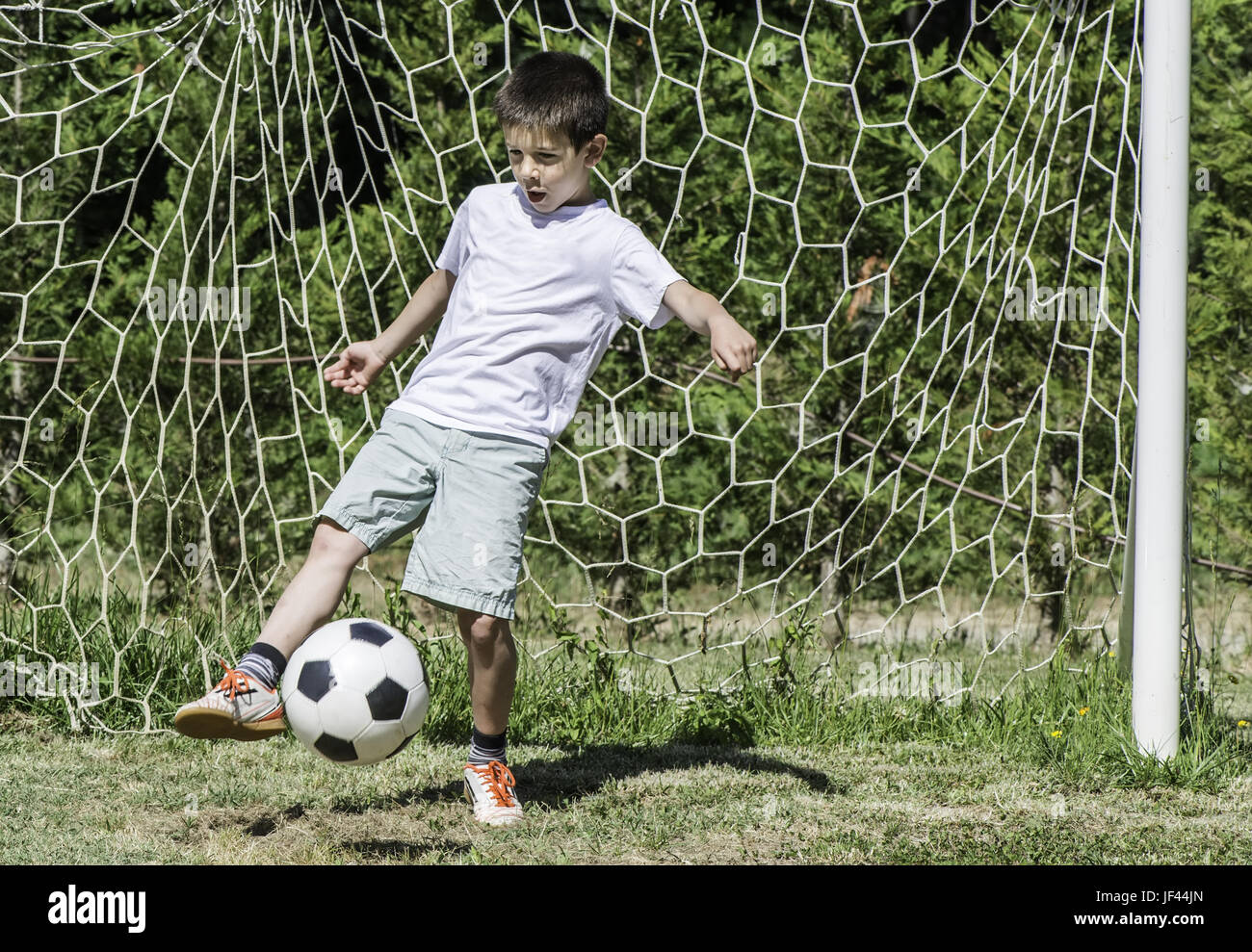 Child playing football in a stadium Stock Photo - Alamy