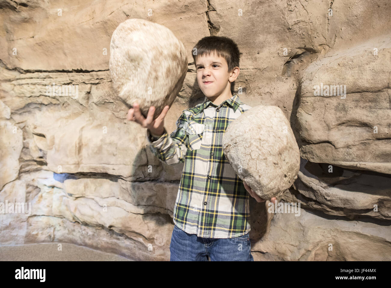 Strong child holds heavy stone Stock Photo - Alamy