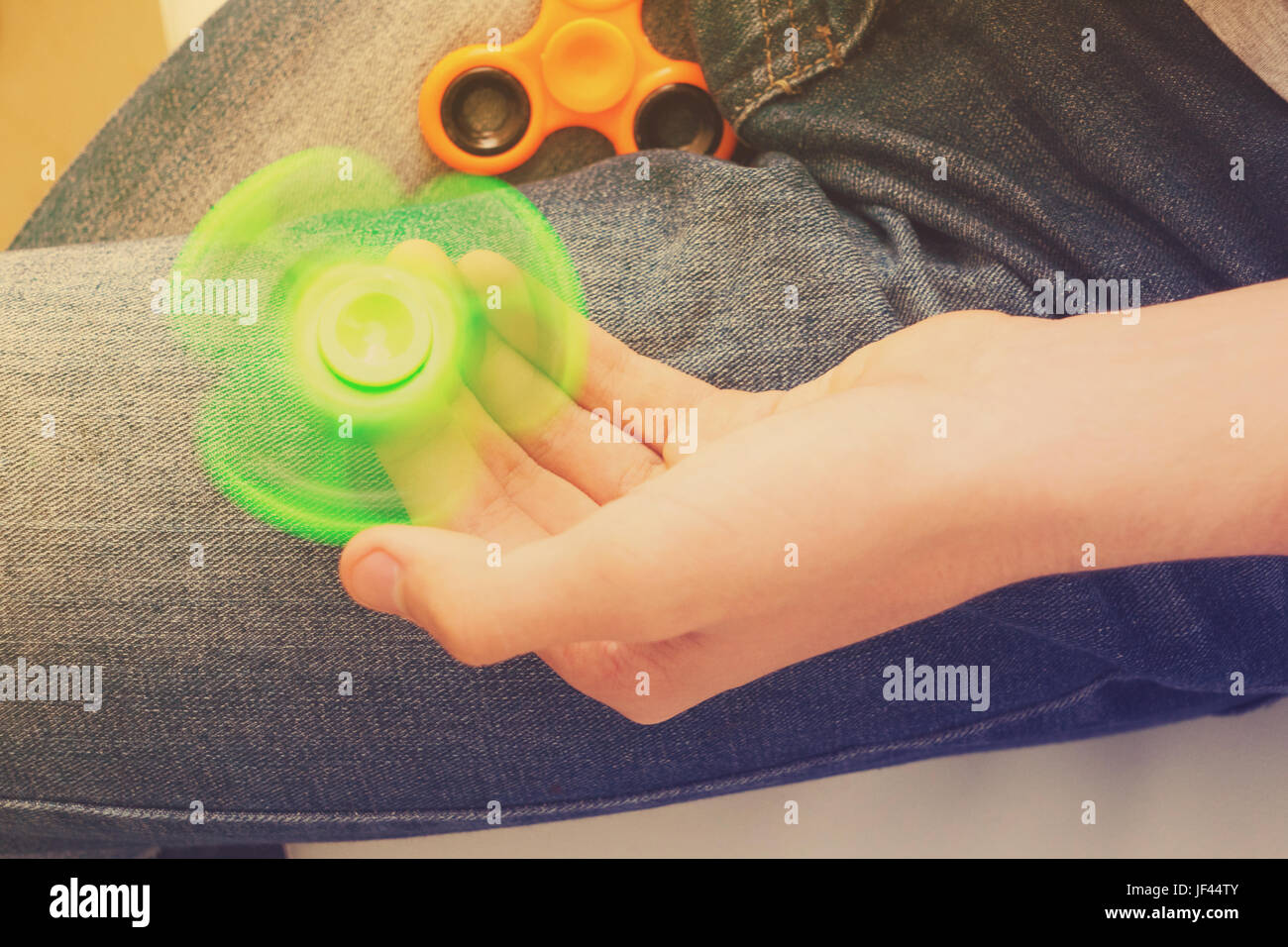 trendy fidget spinner - person holding spinning green fidget spinner in ...
