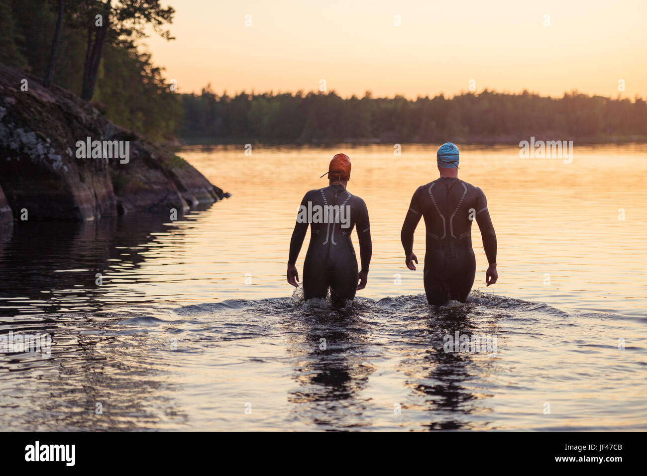 People in water at sunset Stock Photo - Alamy