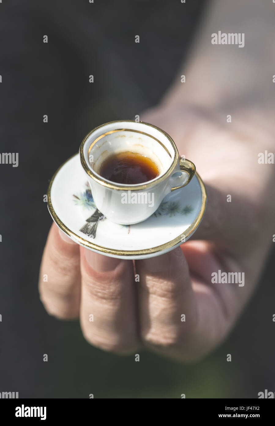 Hand hold small cup of coffee Stock Photo - Alamy