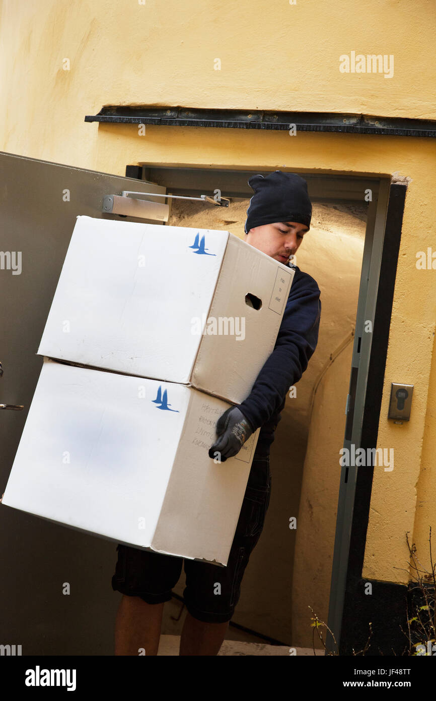 Man carrying moving boxes Stock Photo - Alamy