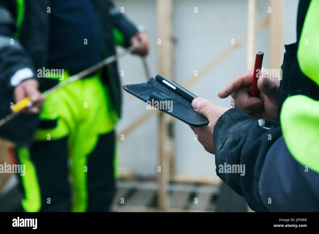 Mid-section of construction worker opening note pad Stock Photo - Alamy