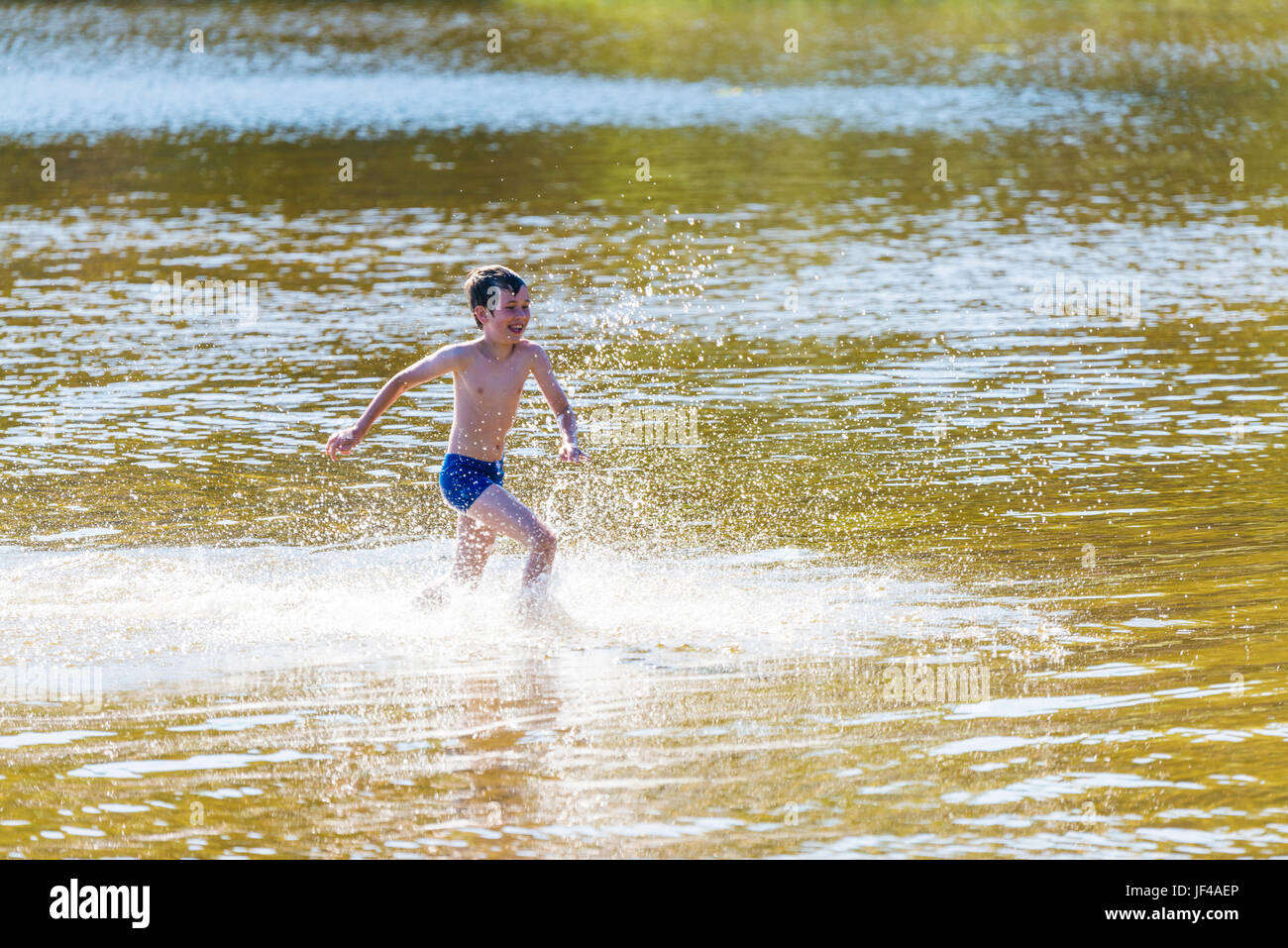 Boy running in water Stock Photo - Alamy