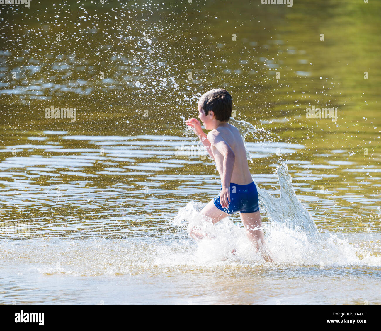 Boy running in water Stock Photo - Alamy